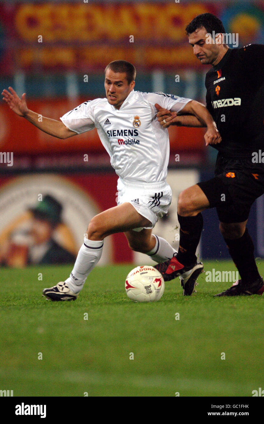 Real Madrid's Michael Owen holds off the challenge of Roma's Traianos ...