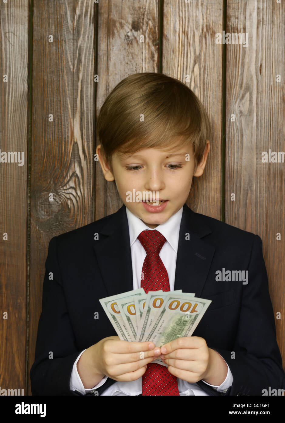 Boy in a suit with cash dollars - business concept Stock Photo - Alamy