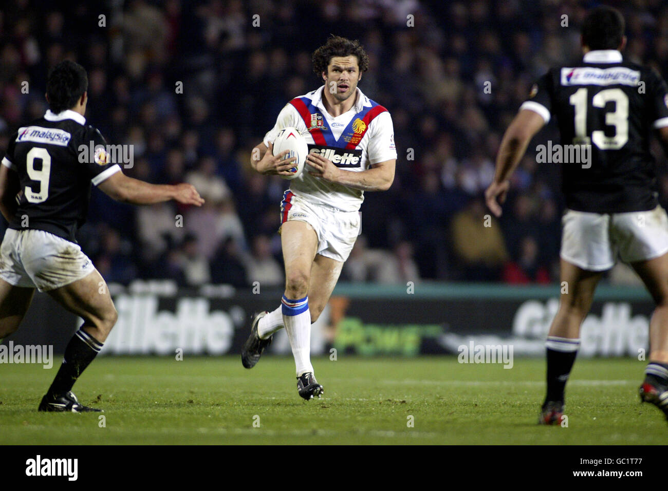 Great Britain's Andy Farrell (c) runs between New Zealand's Louis ...