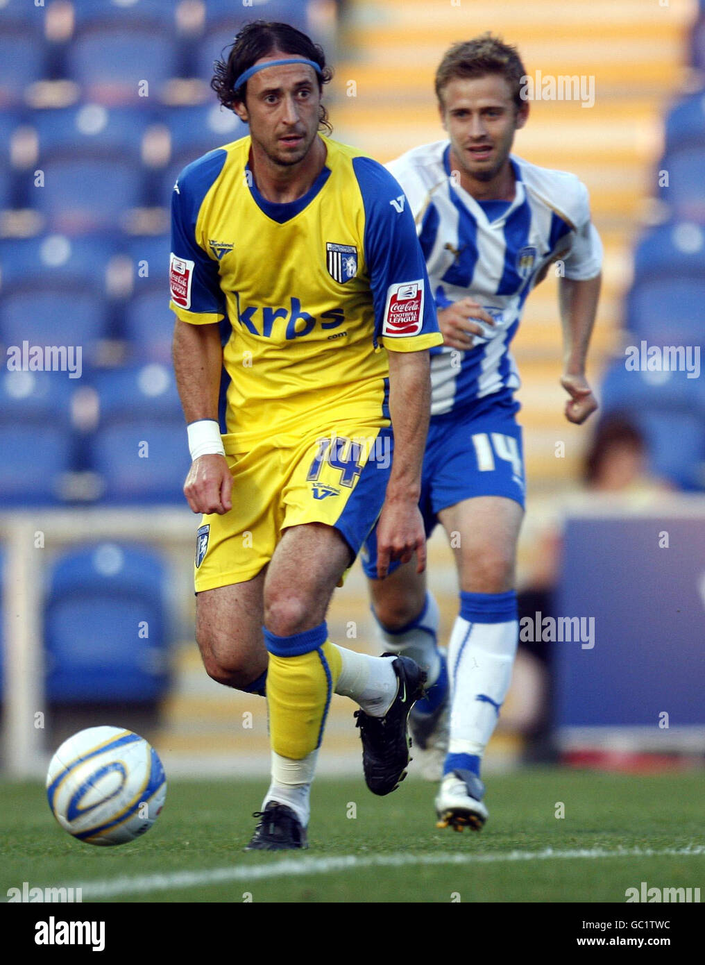 Gillingham's Adam Miller (left) runs with the ball watched by ...