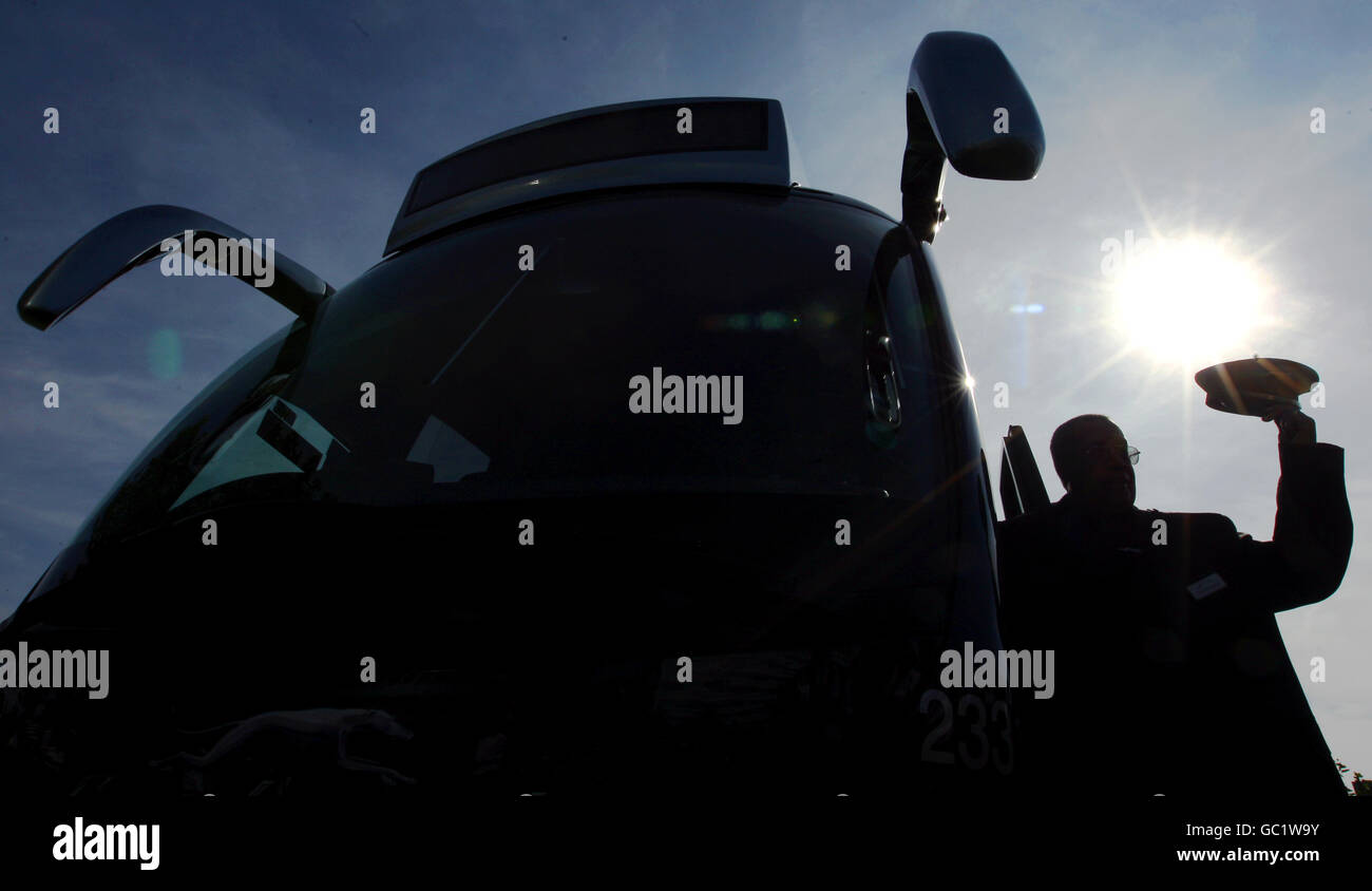 Coach Driver Leon Batchelor waves his cap from the door of a Greyhound ...