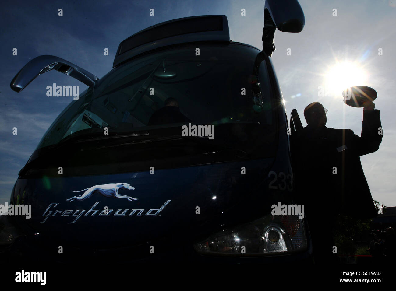 Coach Driver Leon Batchelor waves his cap from the door of a Greyhound ...