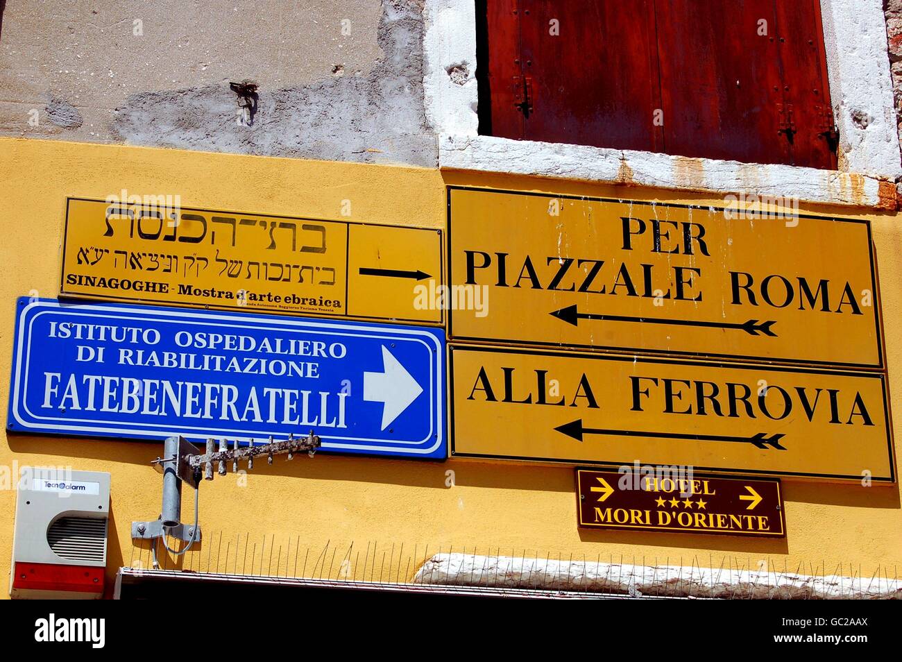 Venice, Italy: Directional signs on the wall of a house pointing to ...
