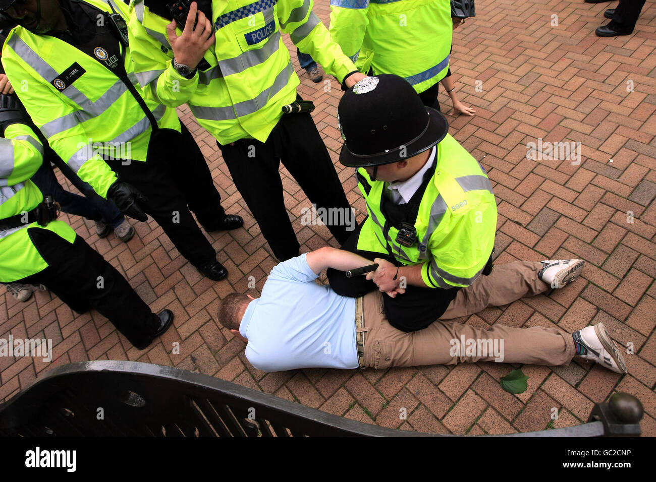 A police officer restrains a man during the English Defence League ...