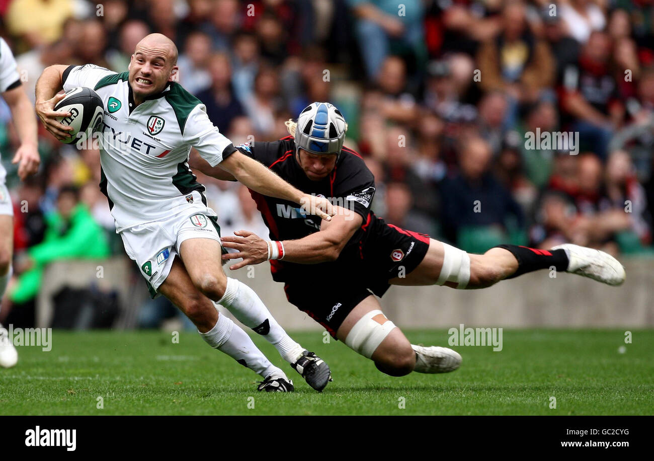 London Irish's Paul Hodgson evades the tackle of Saracens Mouritz Botha ...