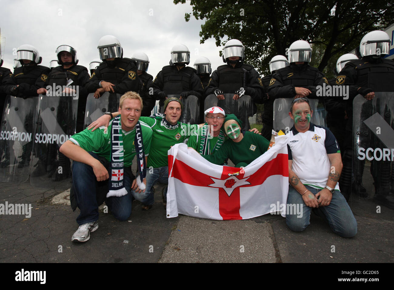 Police in riot gear keep watch as Northern Ireland fans pose for ...