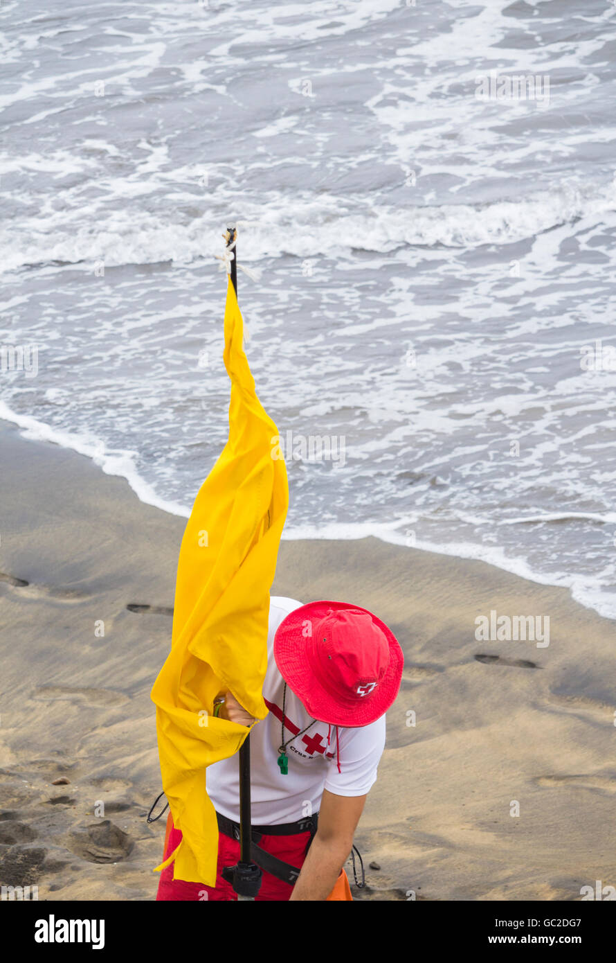 Red Cross lifeguard placing yellow flag on beach in Spain Stock Photo ...
