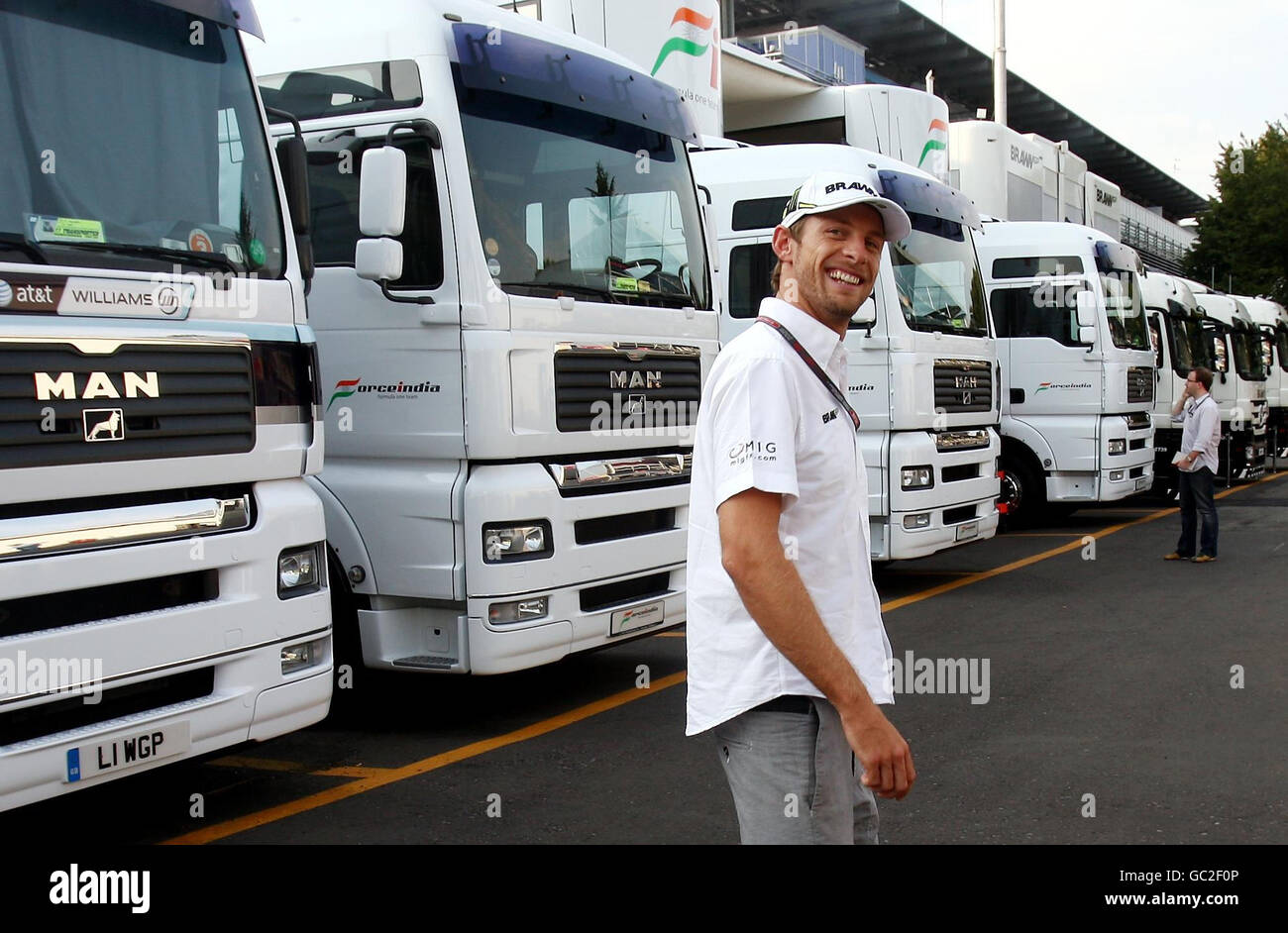 Brawn GP driver Jenson Button smiles as he makes his way through the ...