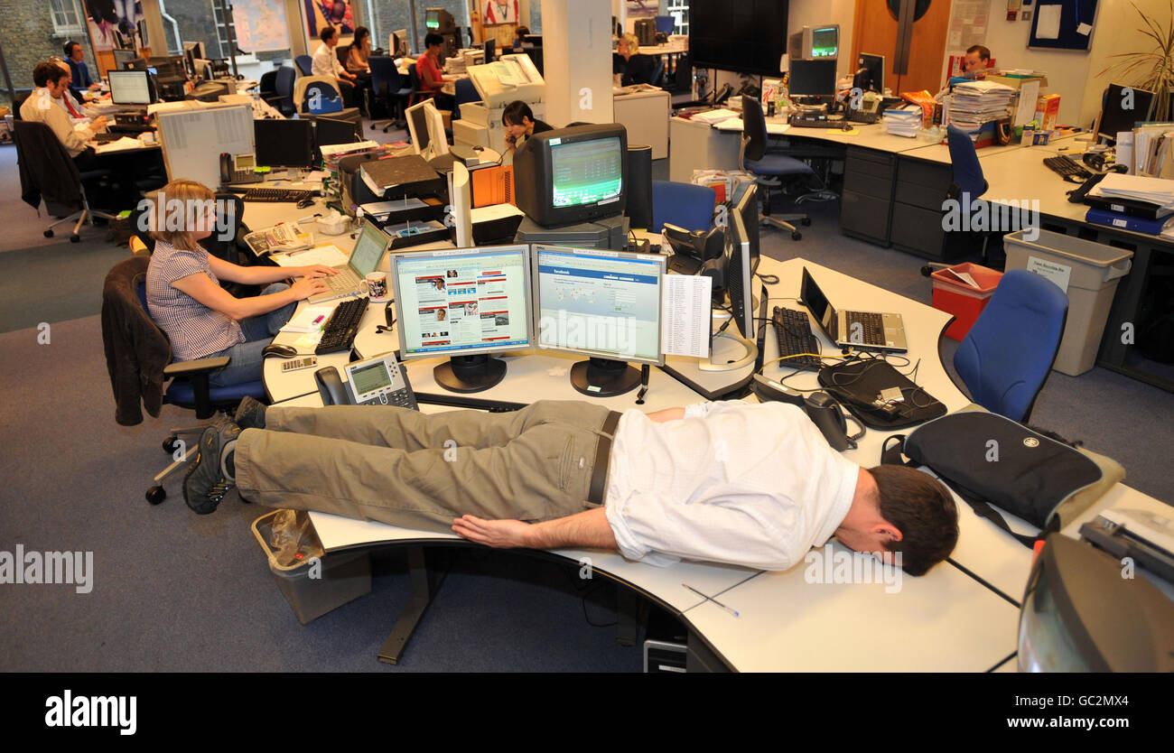An office worker lies face down across a desk hi-res stock photography ...