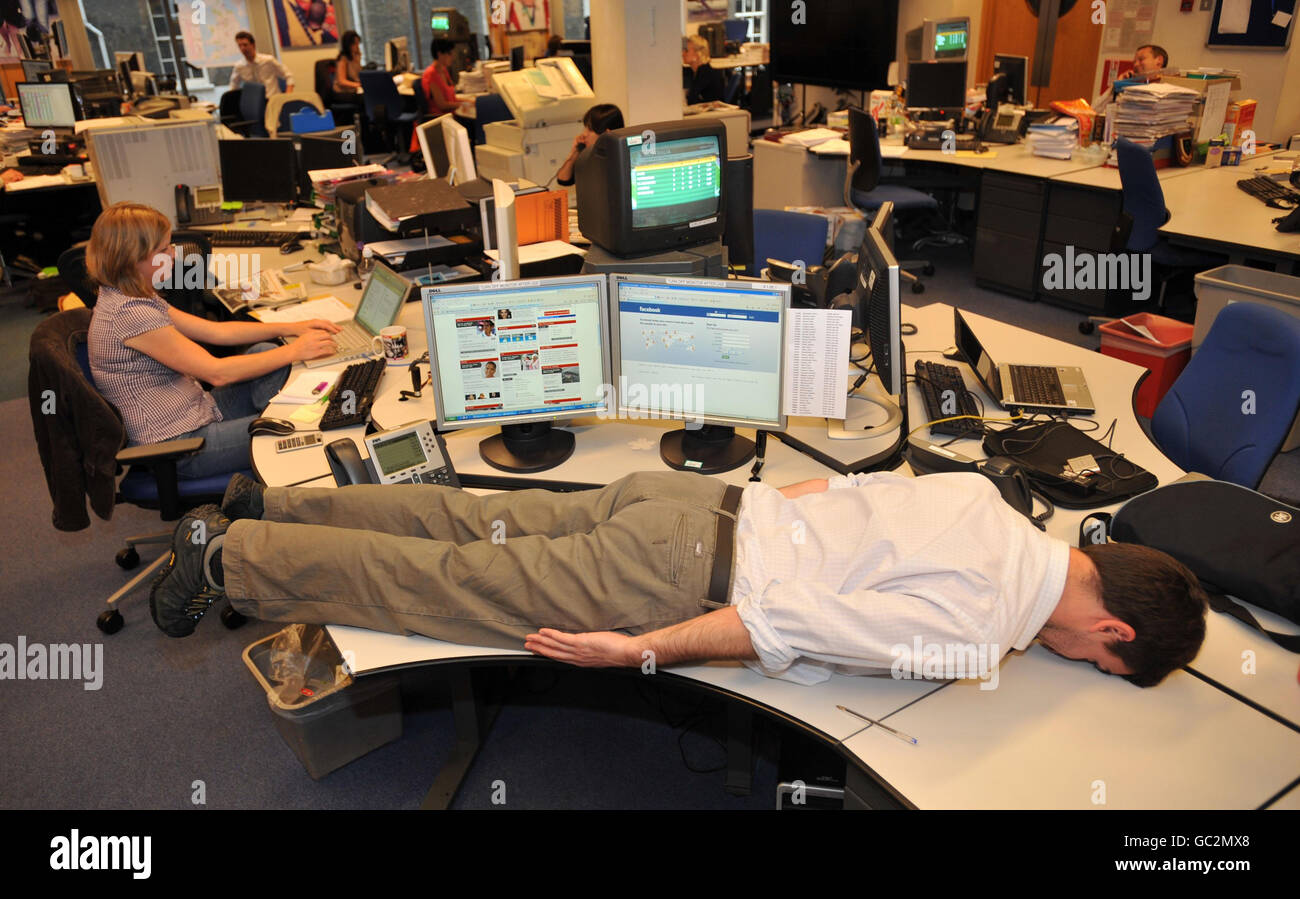 Posed by model: An office worker lies face-down across a desk Stock ...