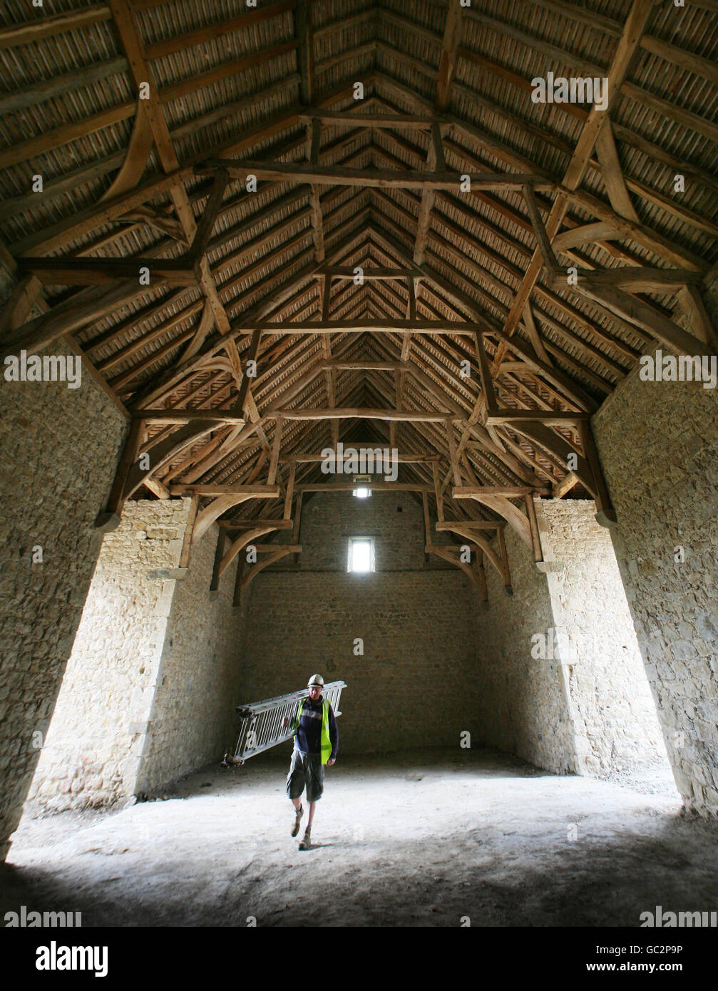 A workman in an Elizabethan barn with a rare hammerbeam roof, built in ...