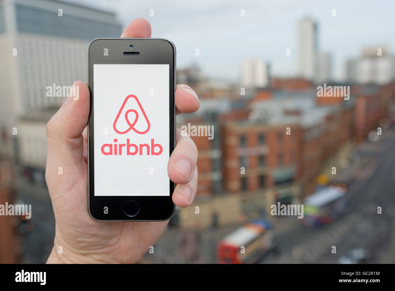 A man uses the Airbnb smartphone app while stood in a tall building ...