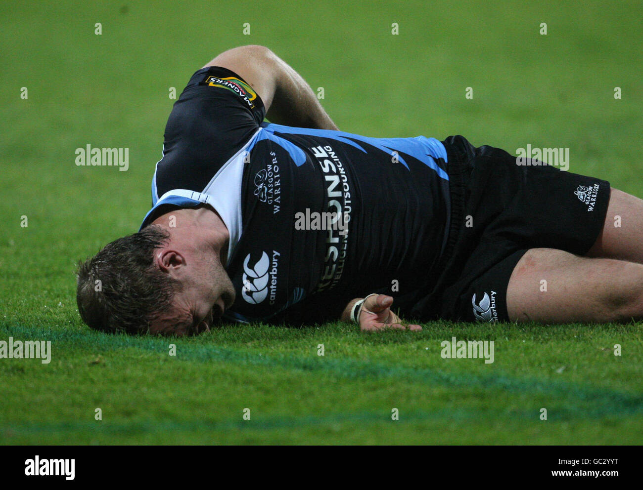 Glasgow's Mark McMillan lies injured during the Magners League match at ...