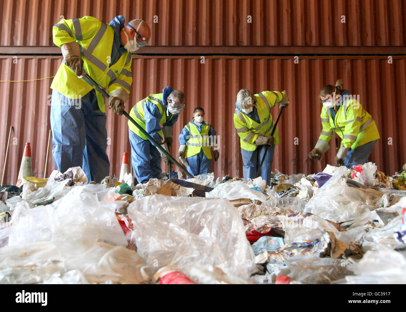 Environment Agency workers inspect a shipping container filled with ...