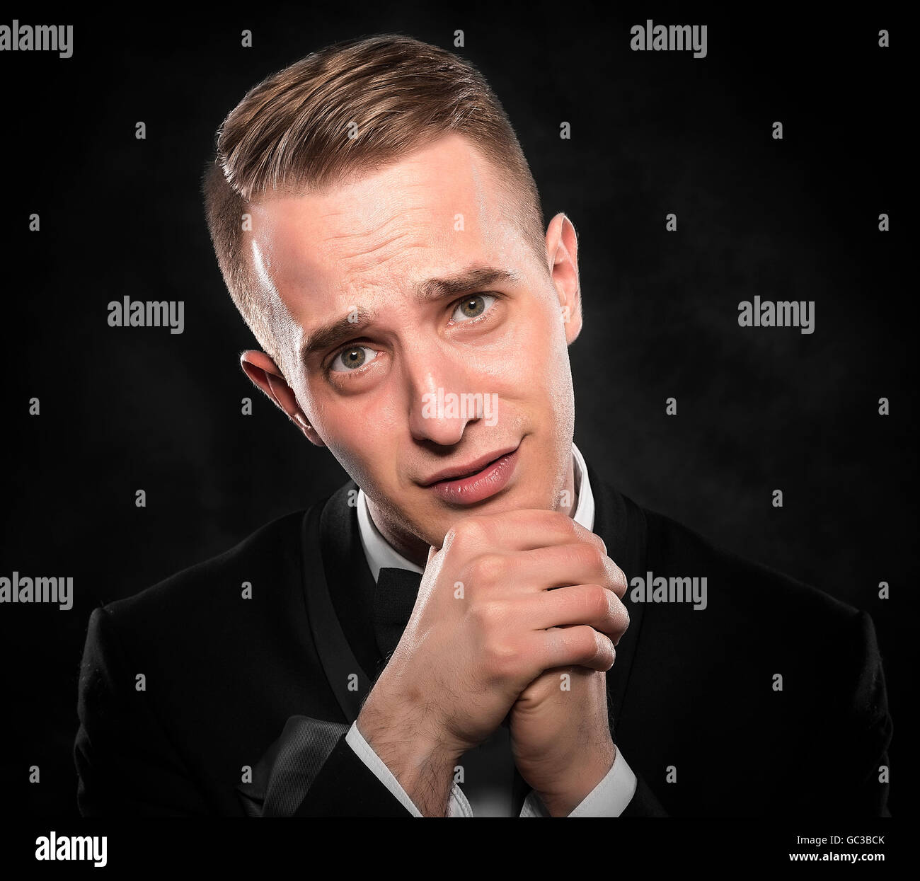 Young man asks for forgiveness on a dark background Stock Photo - Alamy