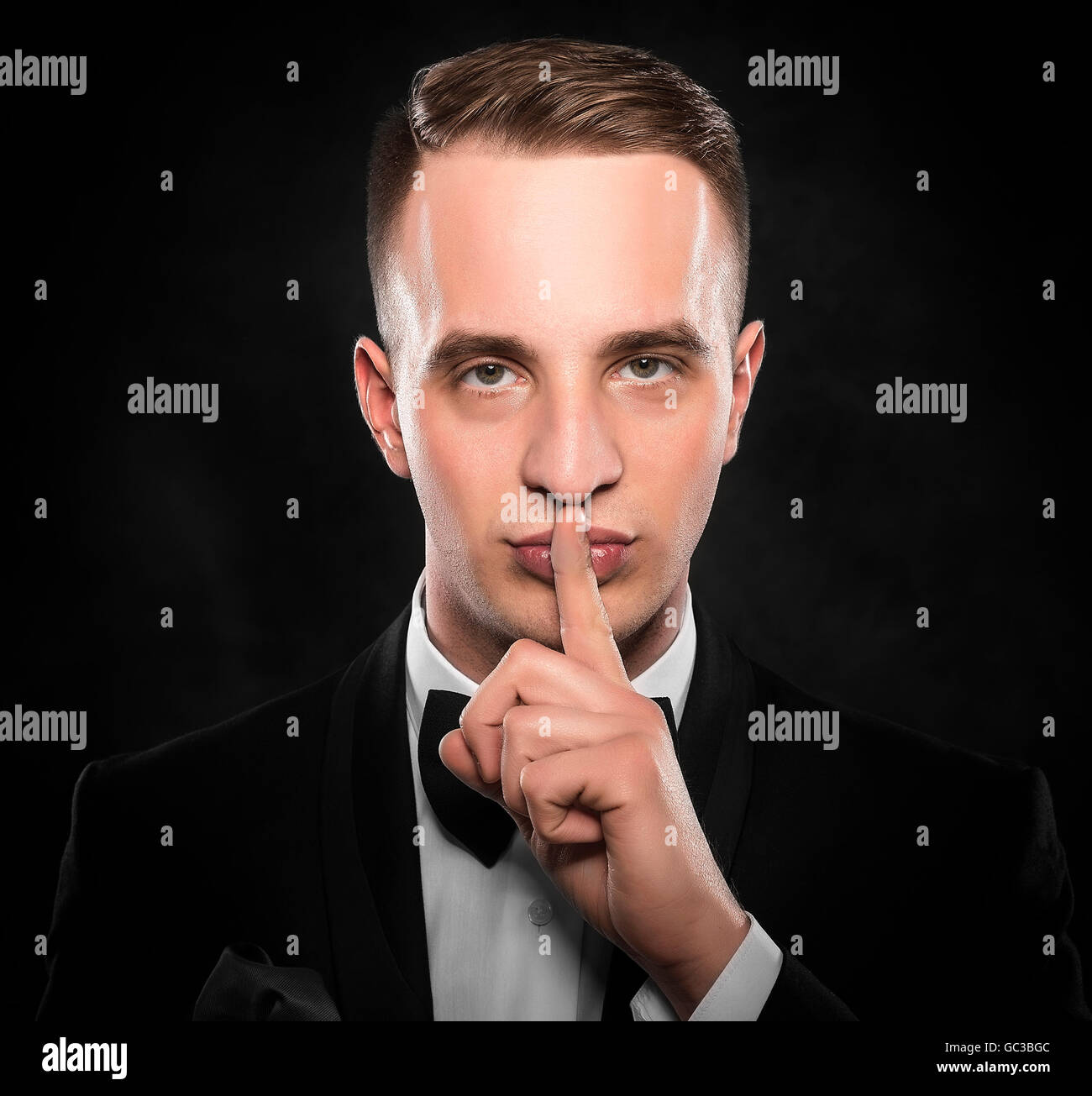 Man gesturing silent on a dark background Stock Photo - Alamy