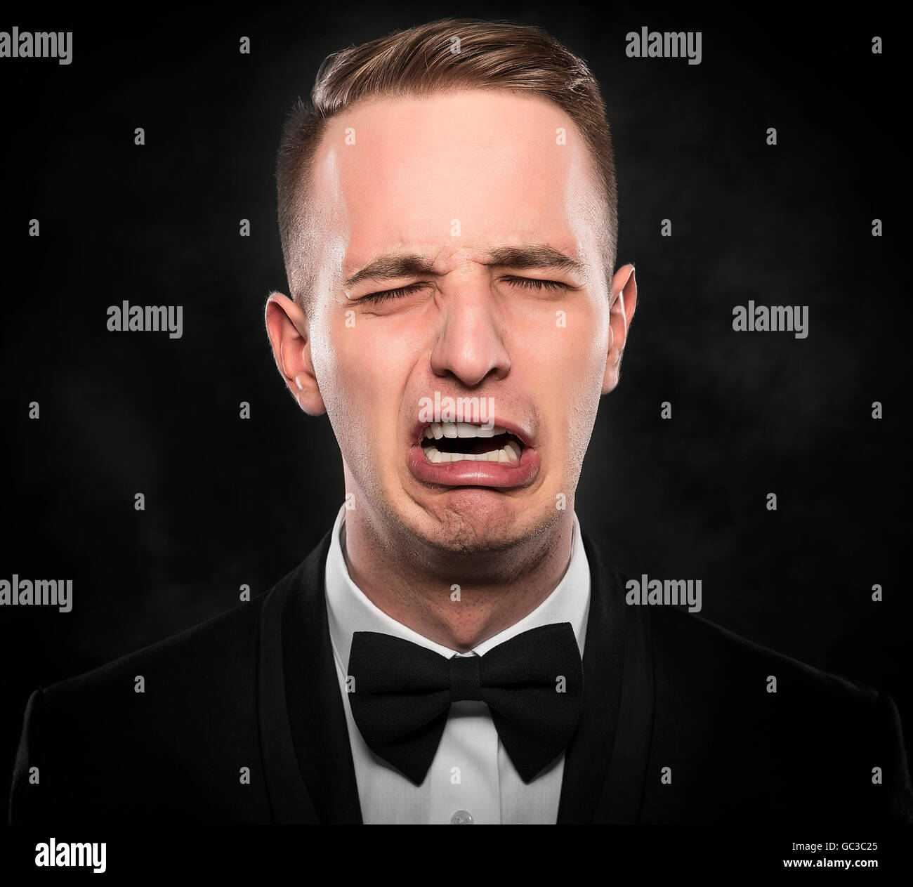 Depressed crying man in black suit over grey background Stock Photo - Alamy