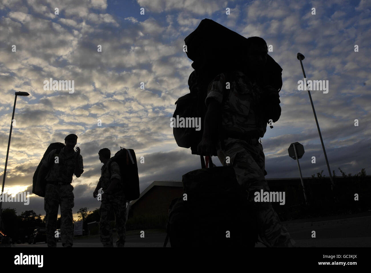 Soldiers carry kit bags and heavy boxes from their bus as 33 Armoured ...
