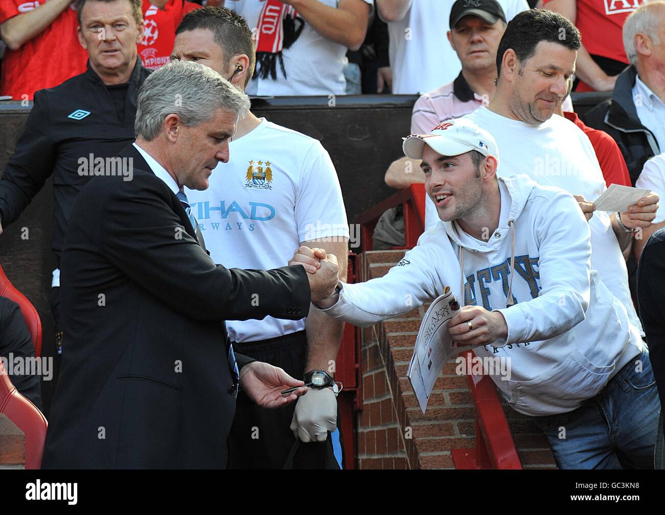 Manchester City manager Mark Hughes signs autographs for fans prior to ...