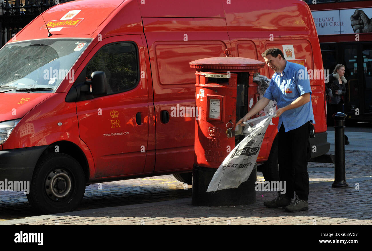 A Royal Mail employee empties a post box in central London following ...