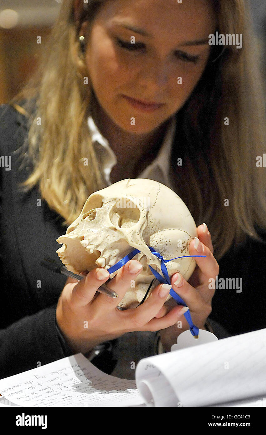 A Bonhams employee examines one of the skulls, owned by the late ...