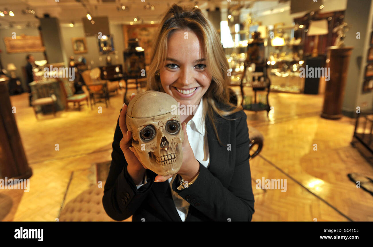 A Bonhams employee examines one of the skulls, owned by the late ...