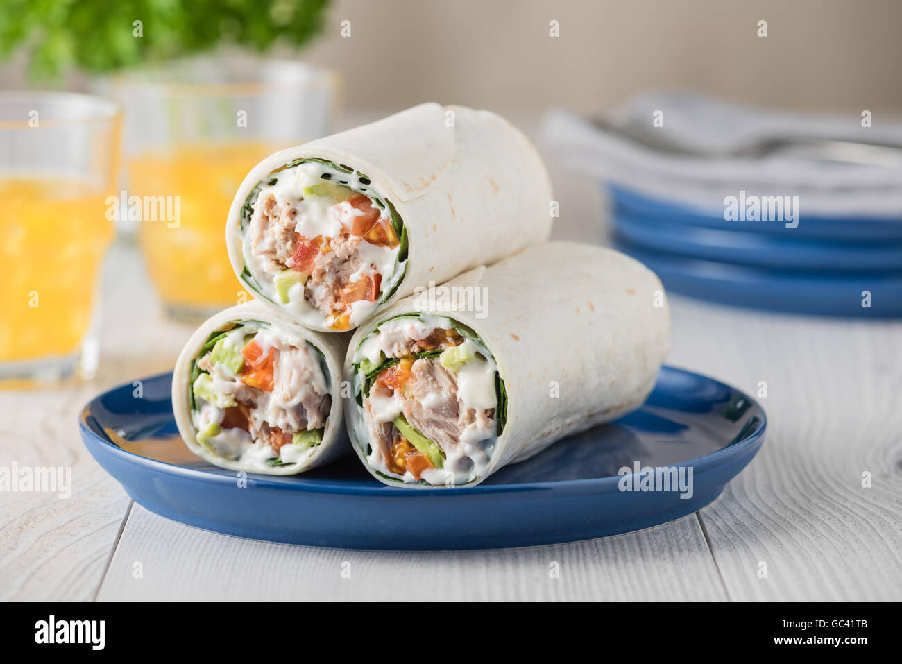 Tuna wraps with avocado tomato and mayonnaise on blue plate Stock Photo ...
