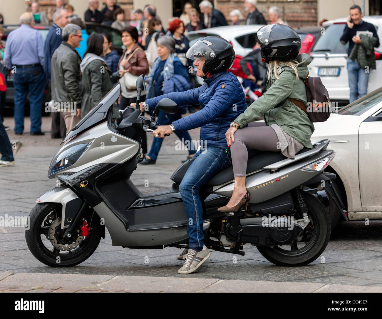 Middle-aged bike rider with his female passenger at the Piazza Castello ...
