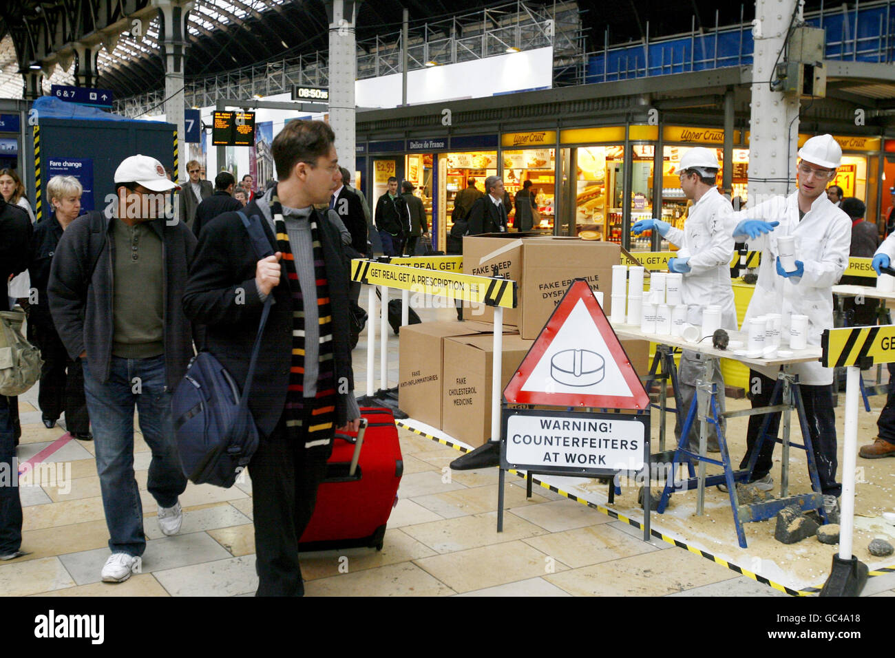Commuters watch as (left to right) 'counterfeiters' Ben Righton and ...