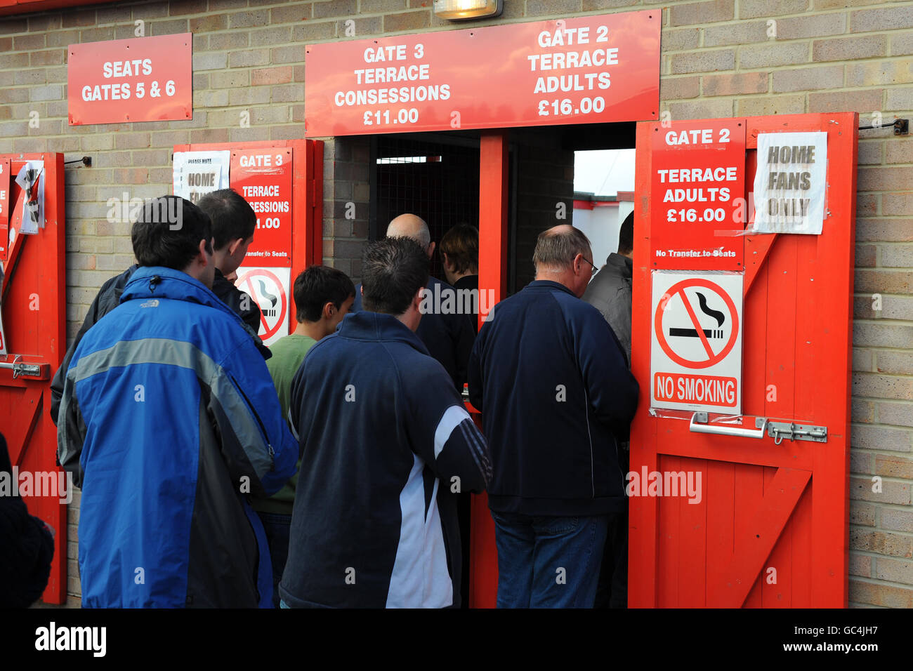Fans make their way into the ground through the turnstiles Stock Photo ...