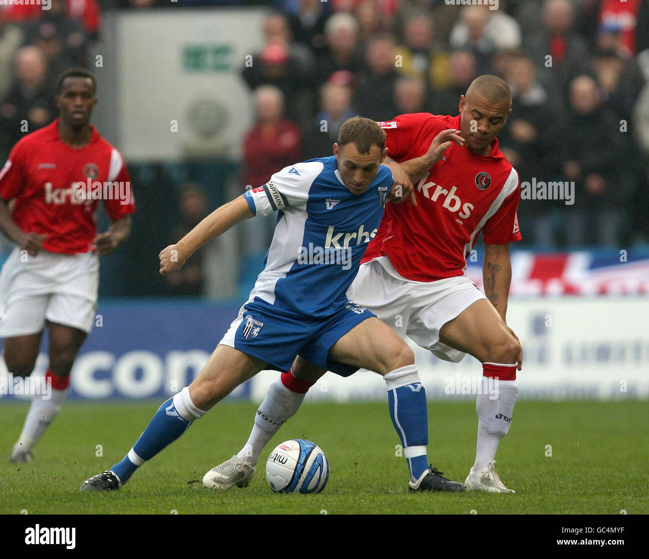Gillingham's Barry Fuller holds off Charlton Athletic's Deon Burton ...