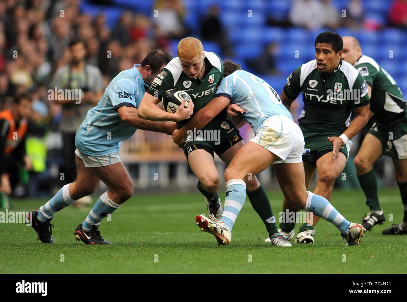 London Irish's Tom Homer (centre) breaks through a challenge from ...