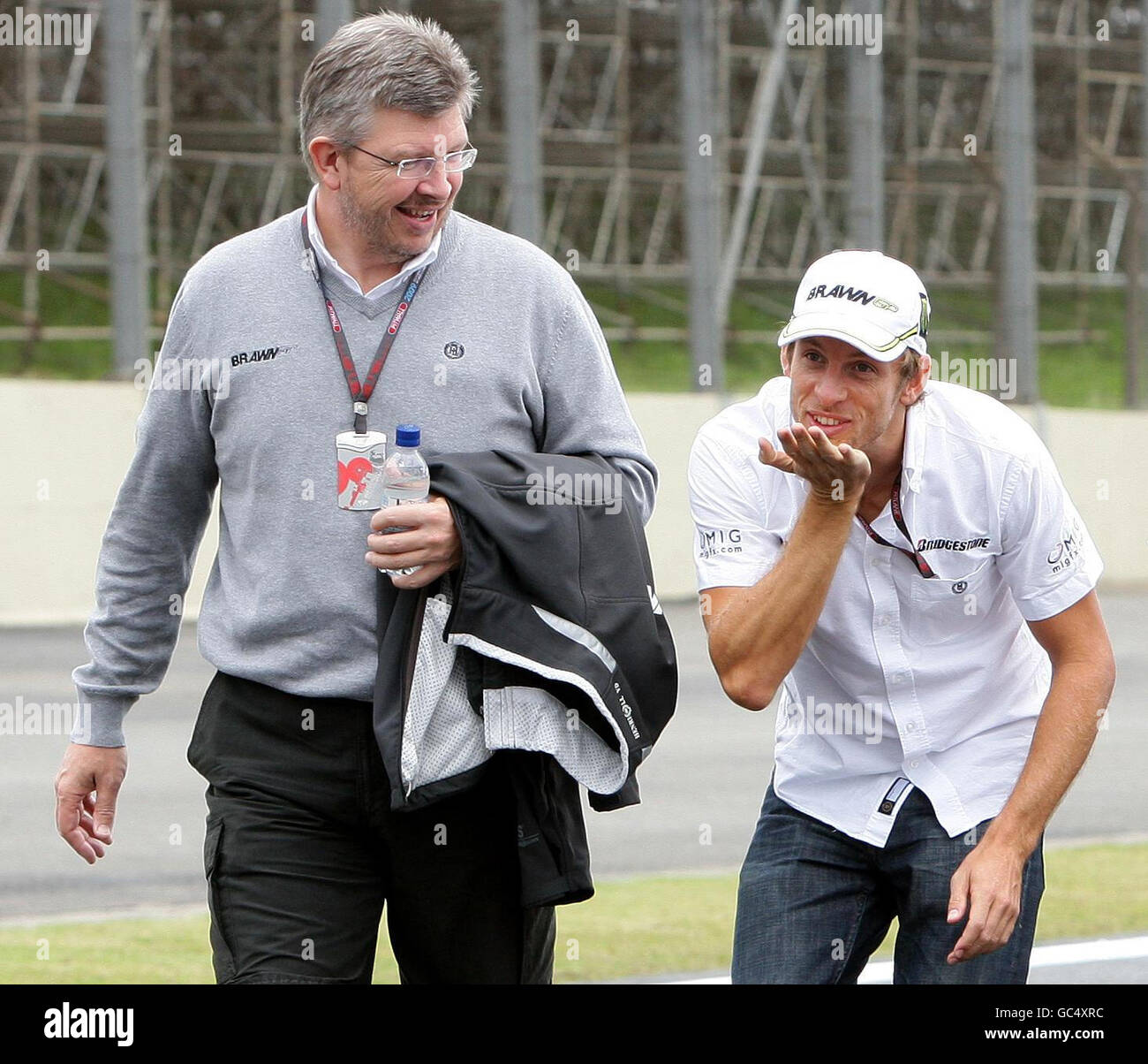 Brawn GP's Jenson Button (right) takes a walk around the track with ...
