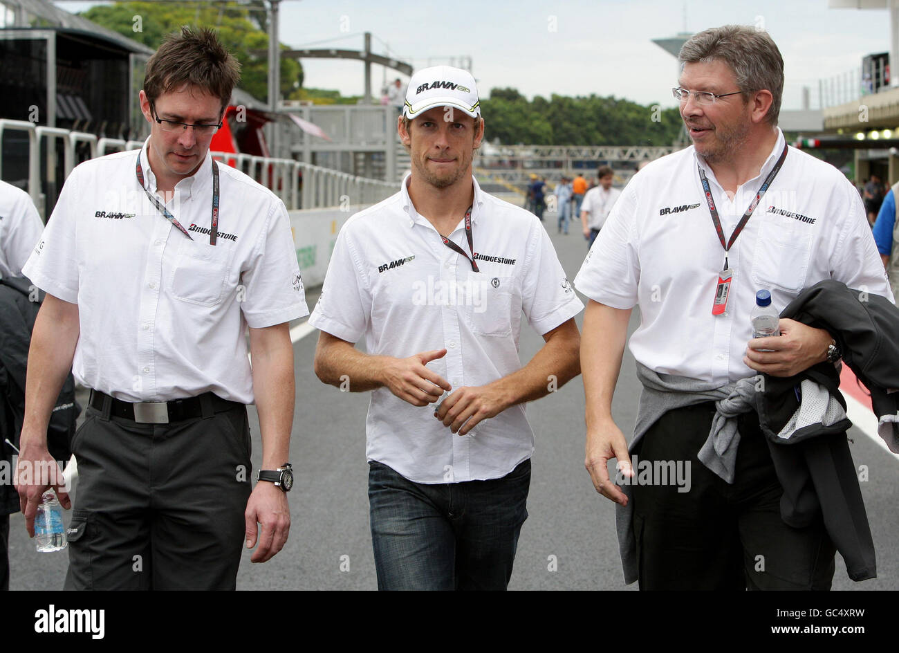 Brawn GP's Jenson Button (centre) takes a walk around the track, with ...