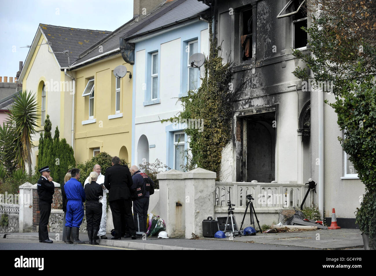 Police and fire forensic teams stand outside a house on Ellacombe ...