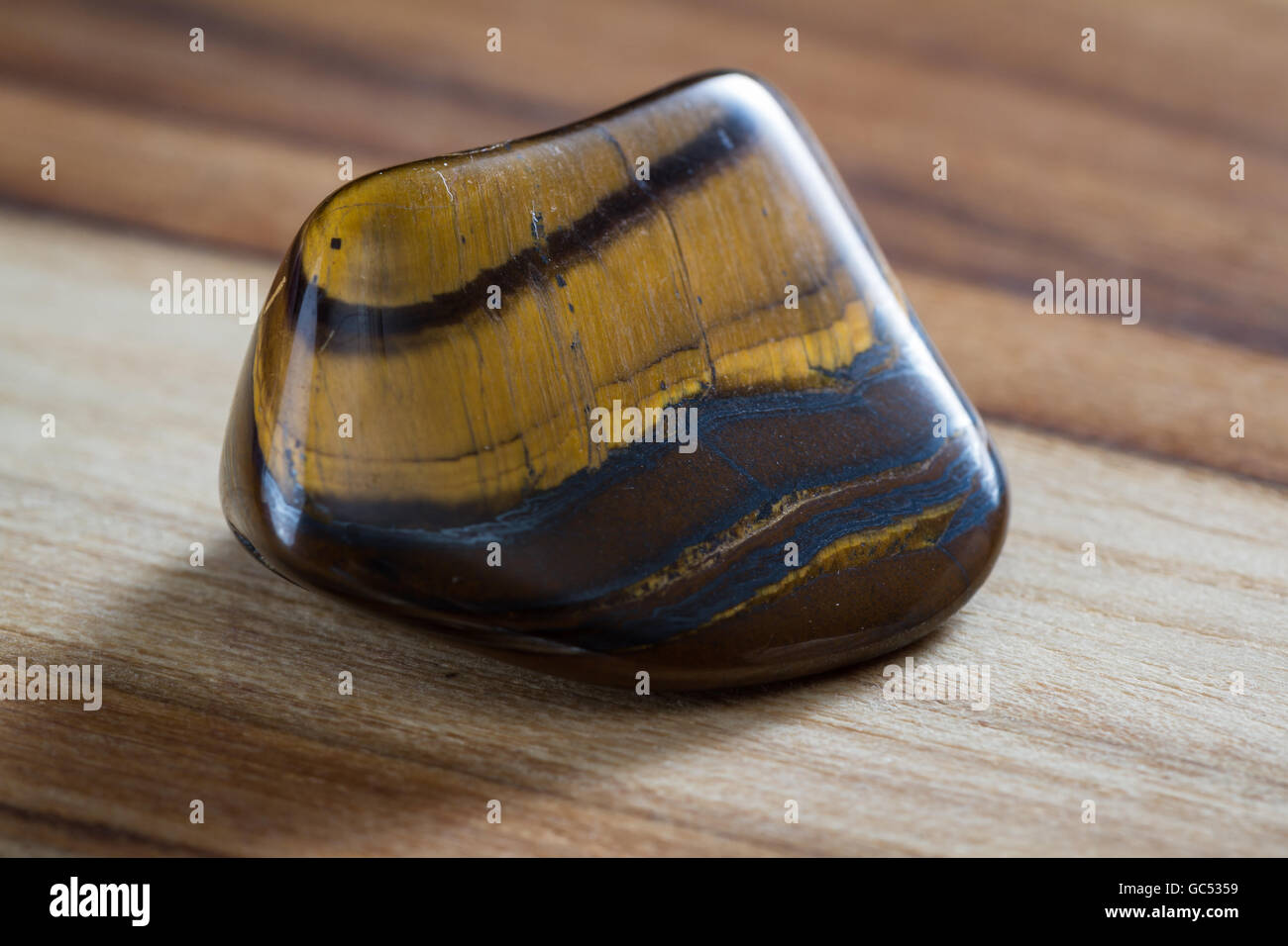 gemstone known as tiger eye or cat eye with a golden color contrasted ...