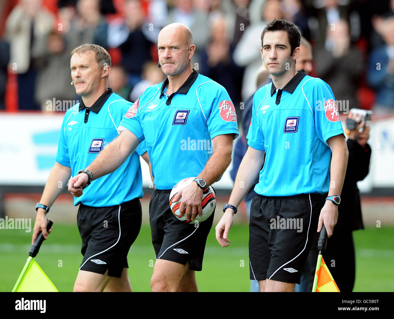 Referee Nigel Miller (centre) walks out before the game with his ...