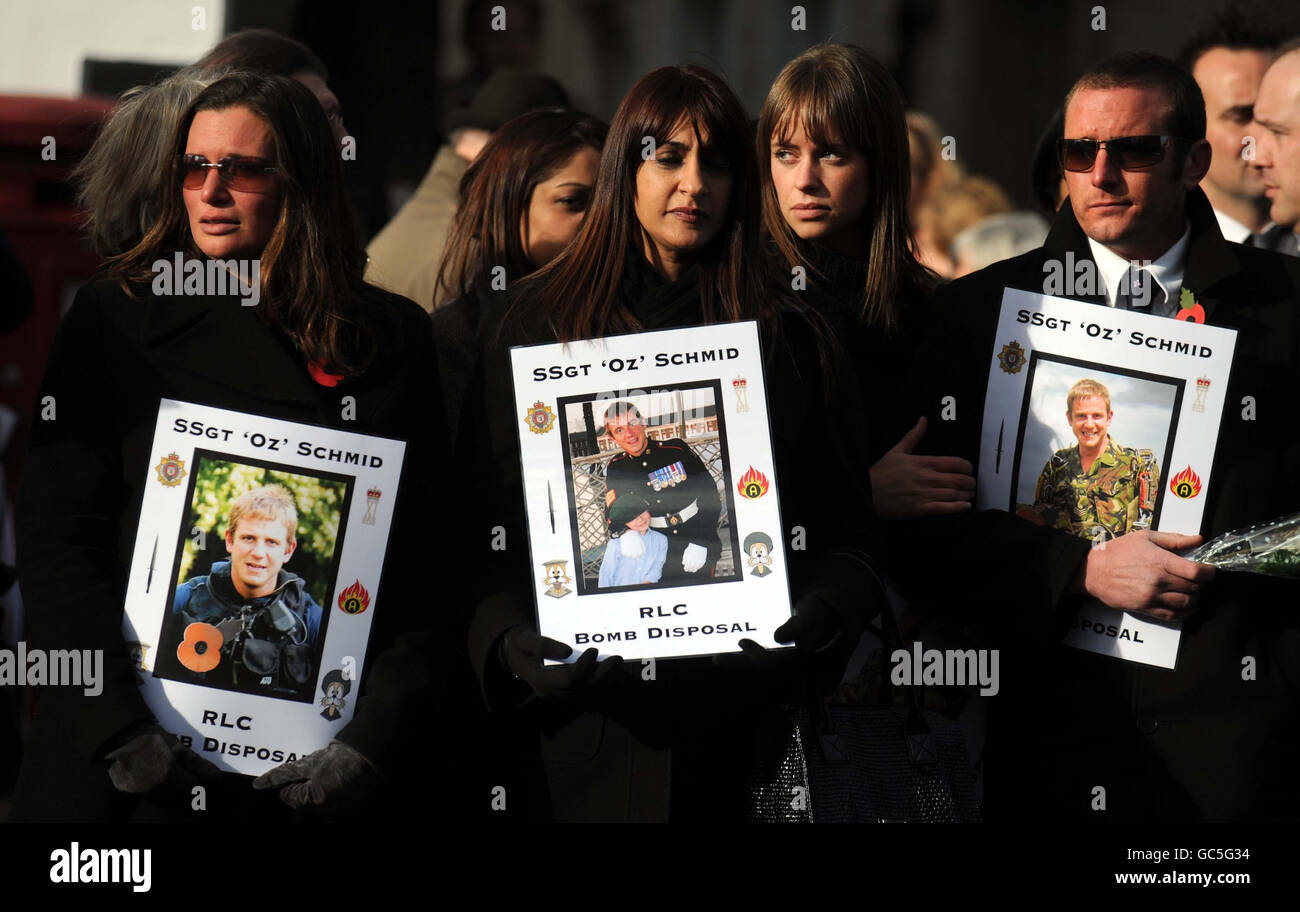 Photos of Staff Sergeant Olaf Schmid are held as his coffin passes ...