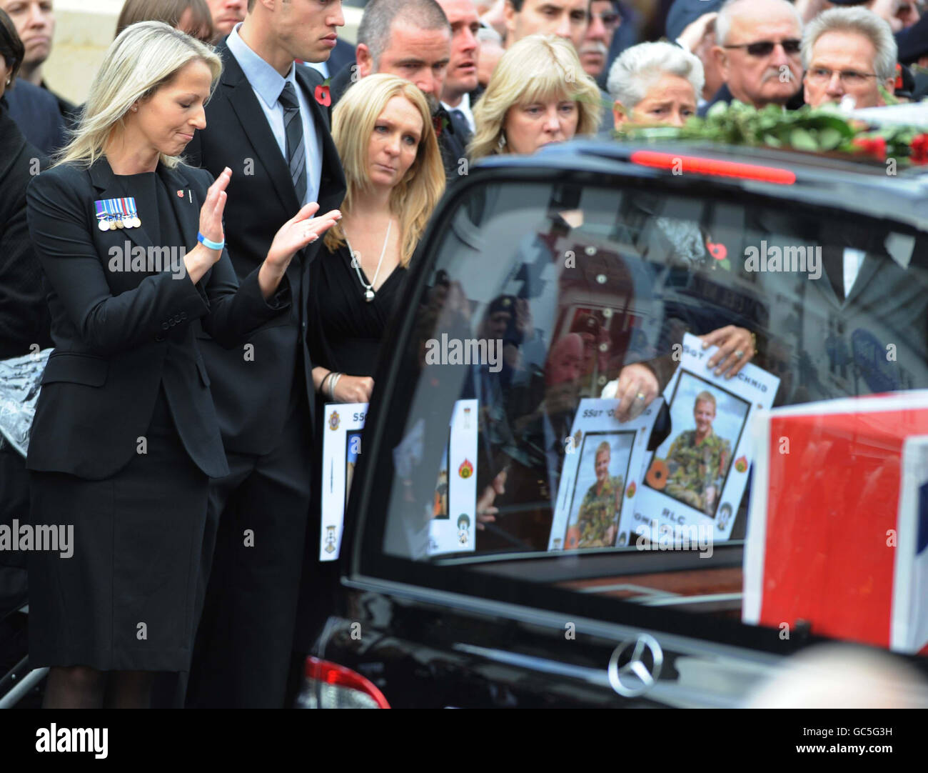 Christina (left) wife of Staff Sergeant Olaf Schmid applauds as the ...