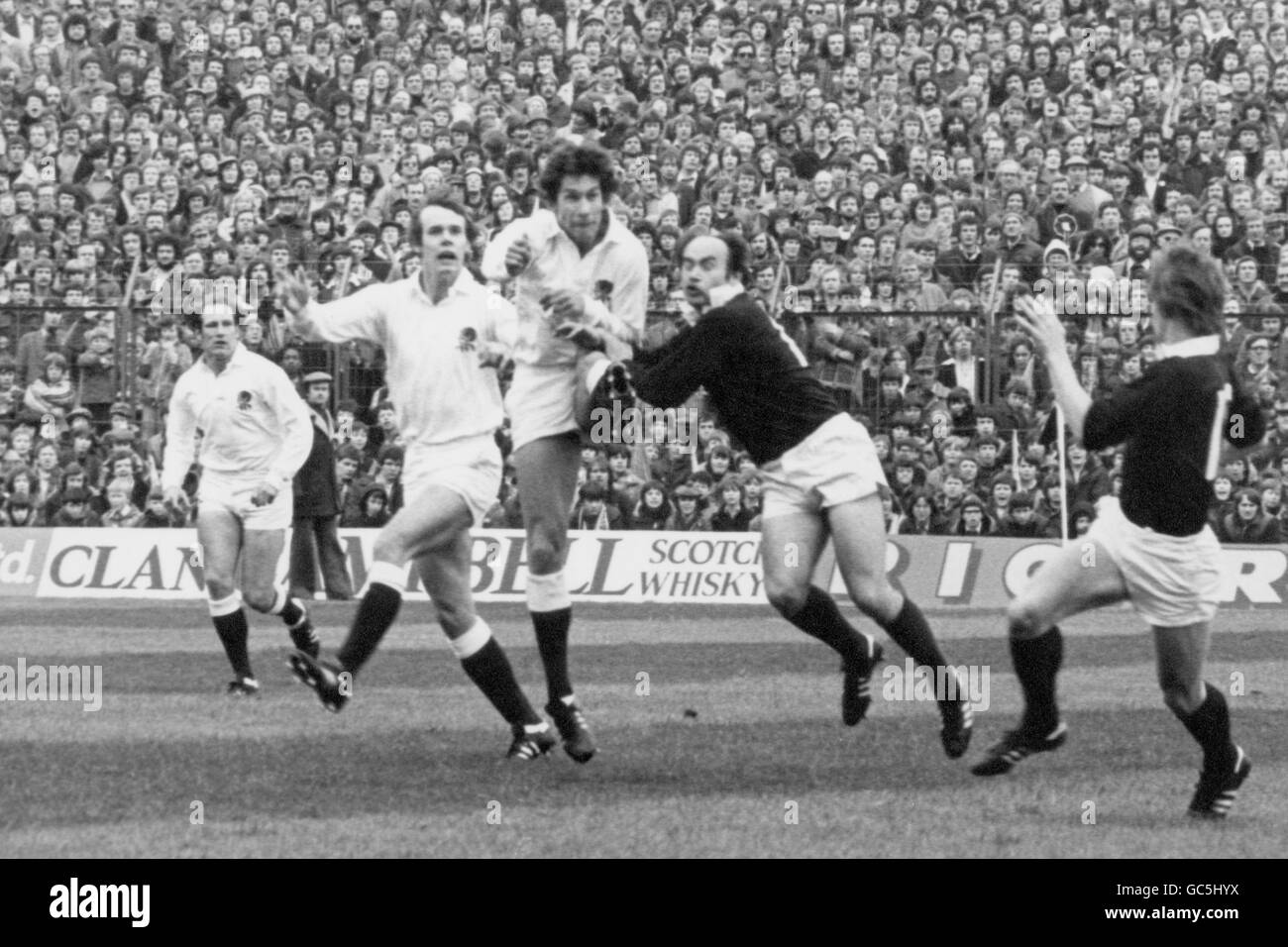 Paul Dodge, centre, clears his line as Scotland's Jim Renwick barges in ...