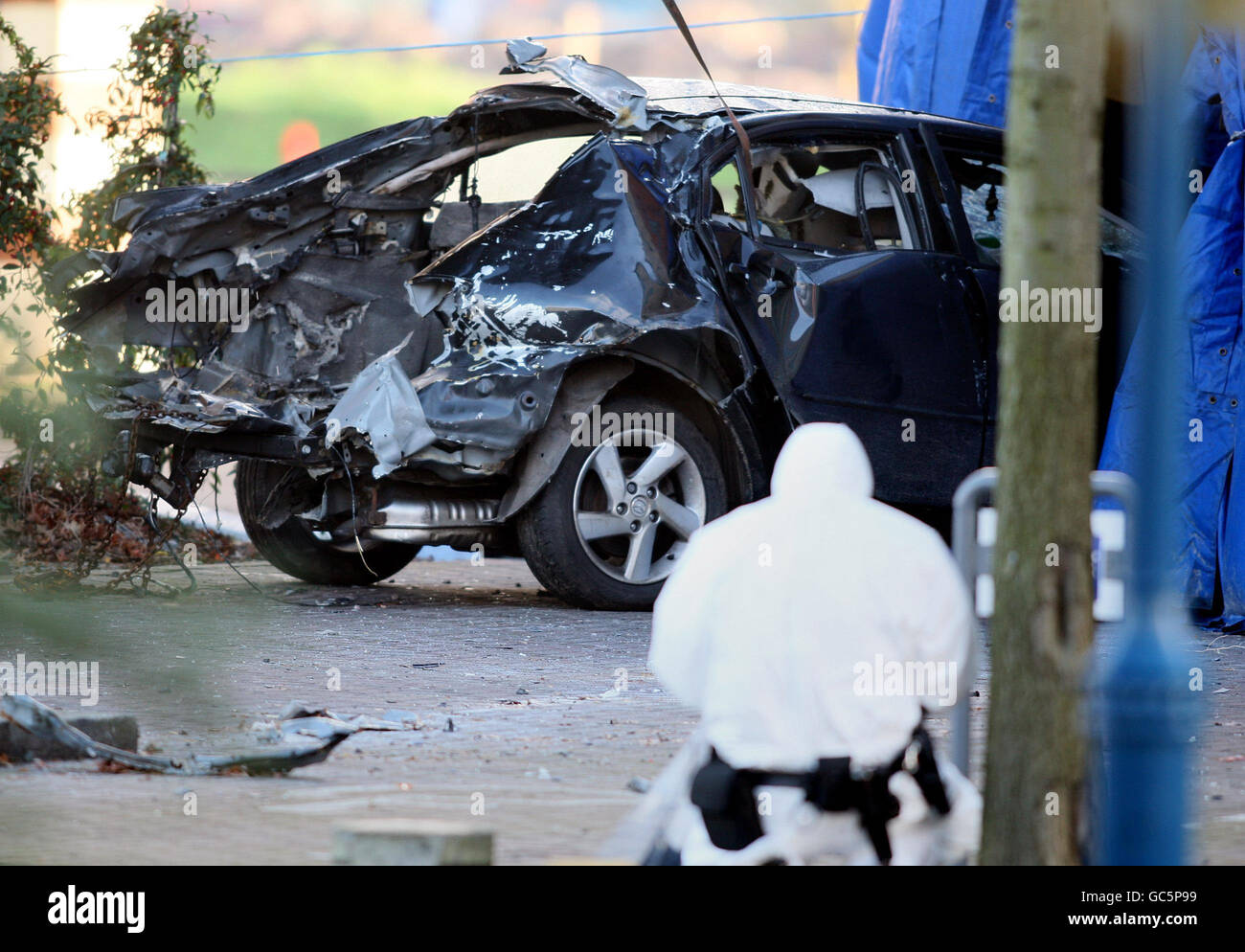 Police forensic officers examine the area around where a car bomb ...