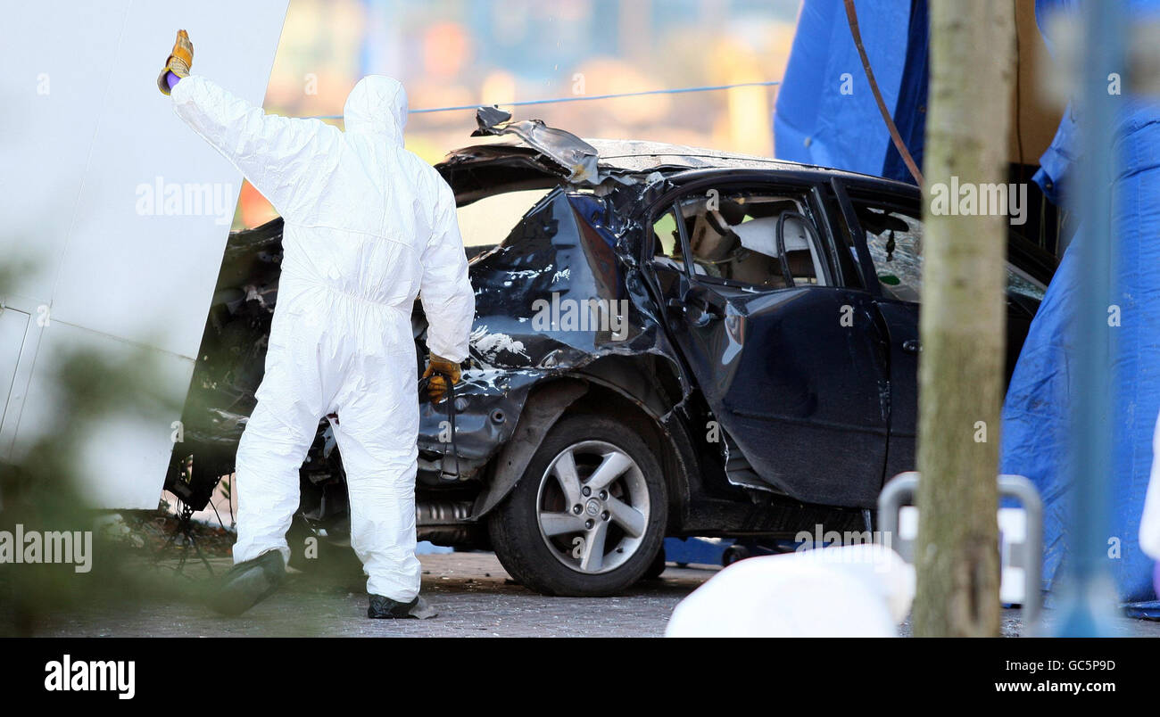 Police forensic officers examine the area around where a car bomb ...
