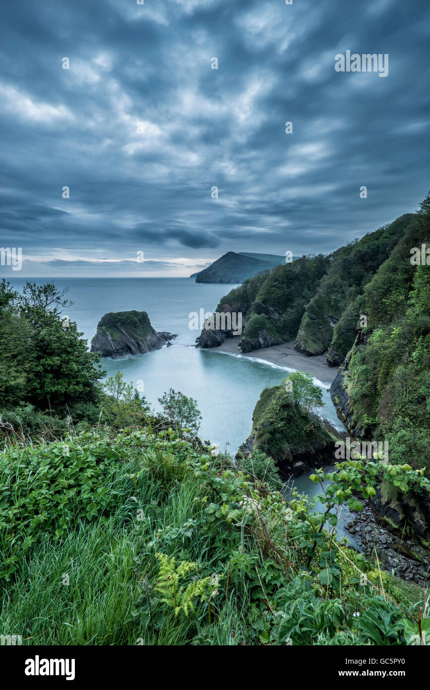 Beautiful moody sunrise landscape image of small secluded cove at Combe ...