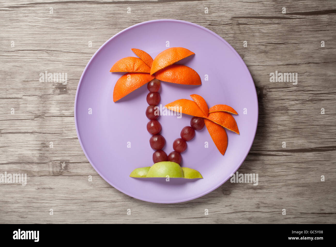 Palm tree made of fruits on plate and wood Stock Photo - Alamy