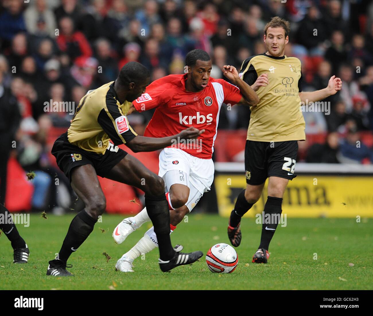 Charlton Athletic's Lloyd Sam (centre) makes his way past Milton Keynes ...