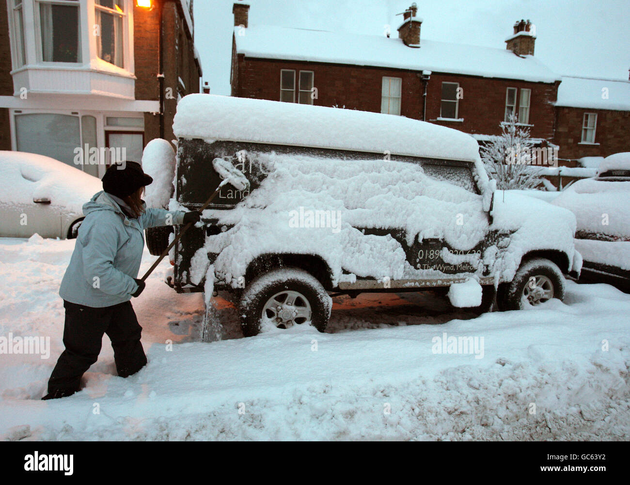 A woman clears snow from her car in St Boswells in the Scottish Borders, after a night of heavy ...