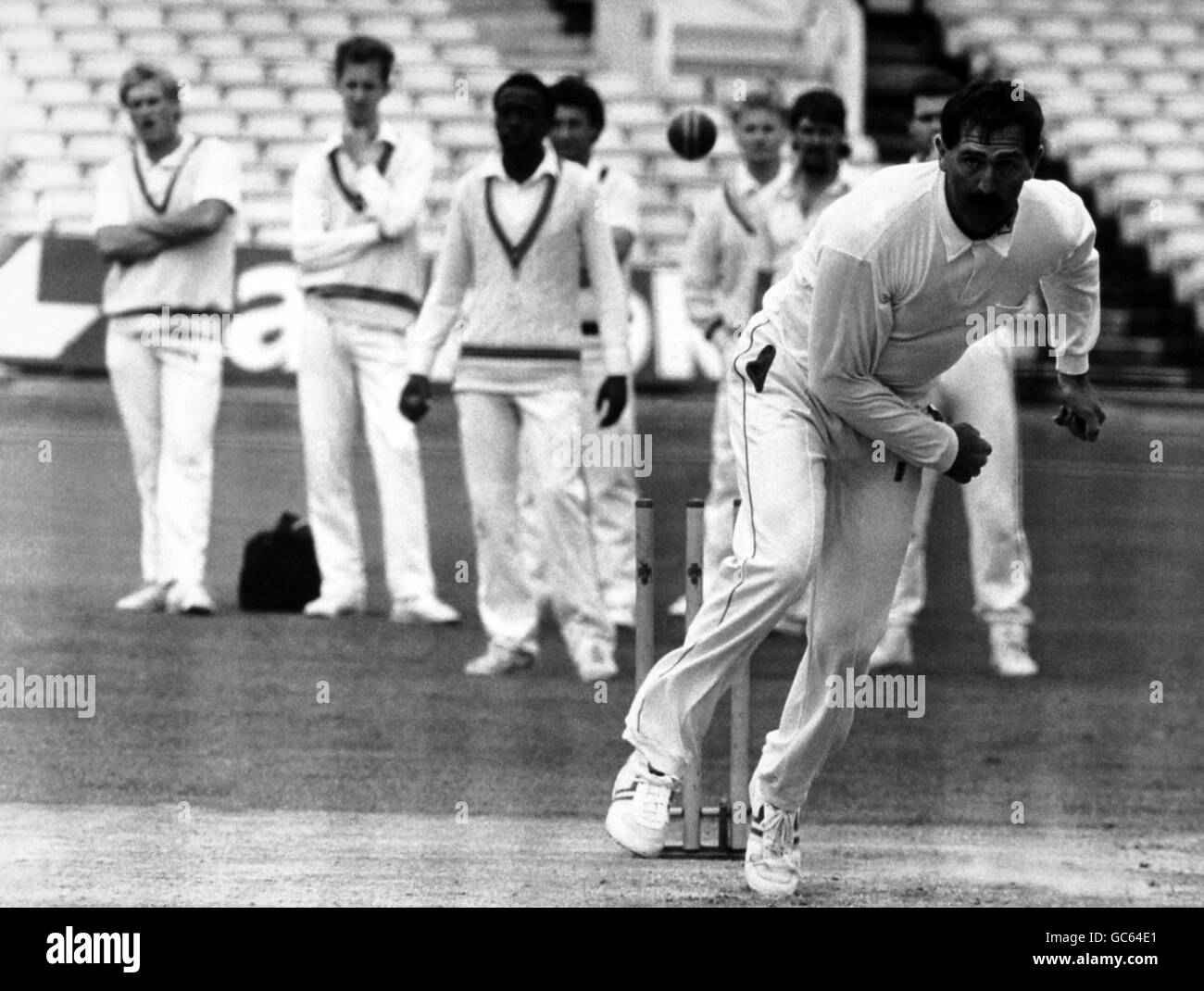 England cricketer Graham Gooch practicing his bowling technique watched ...