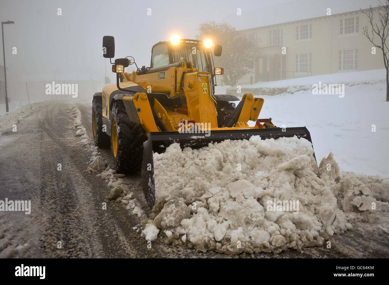 A JCB digger clears snow in Princetown, Dartmoor, Devon, where snow ...