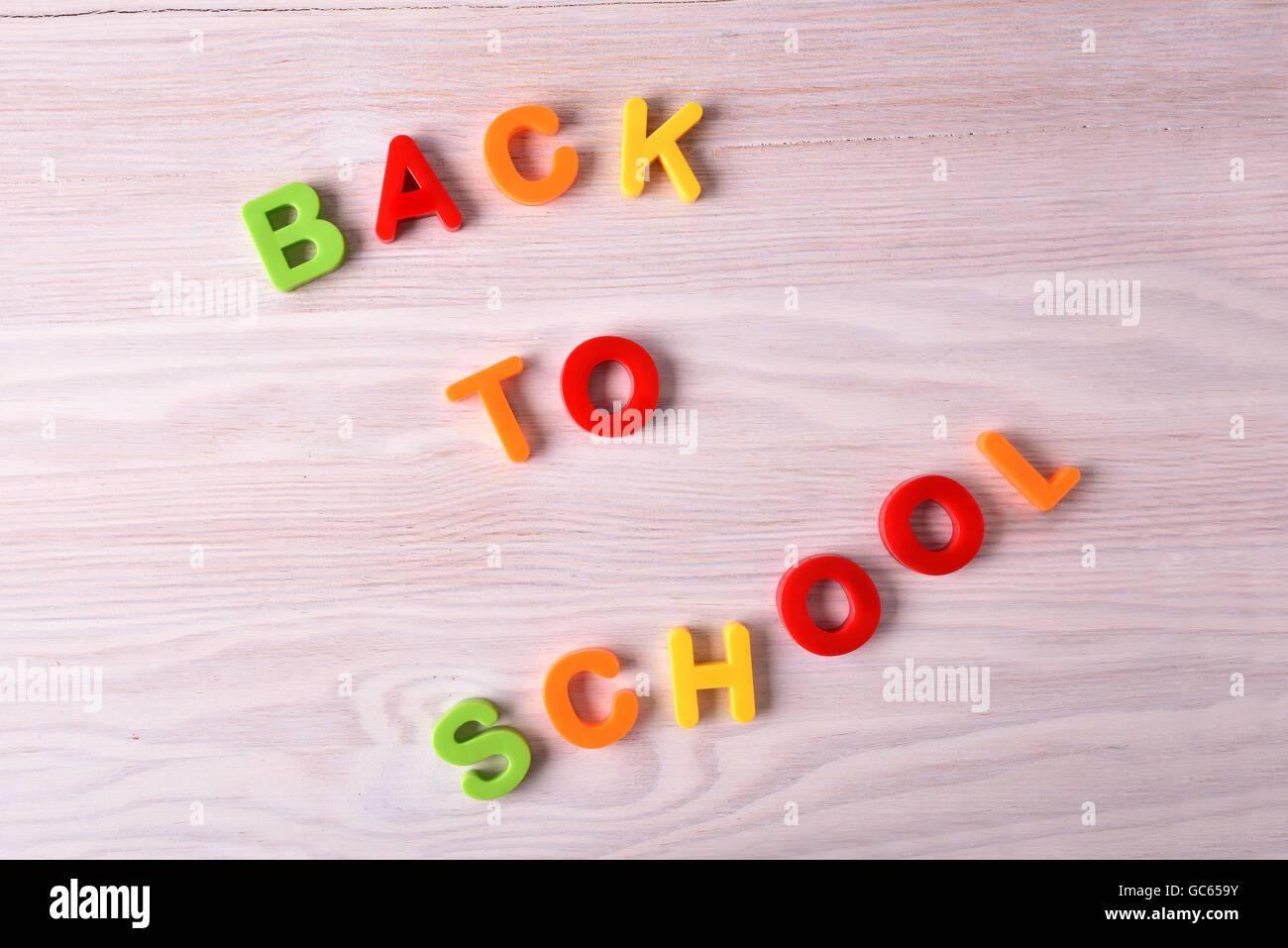 Back to school concept with colorful letters on a brown wooden desk ...