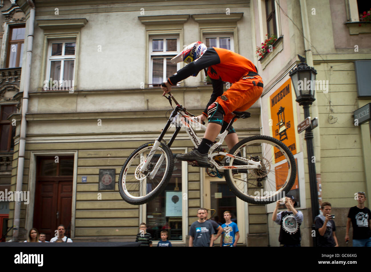 Downhill city tour. Biker jumps over the ramp during mountain bike race ...